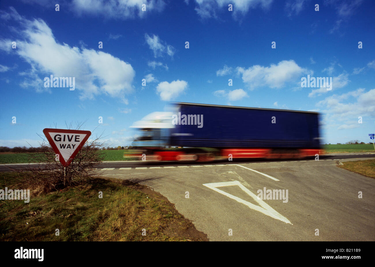 lorry passing give way sign at road t junction uk gb Stock Photo - Alamy