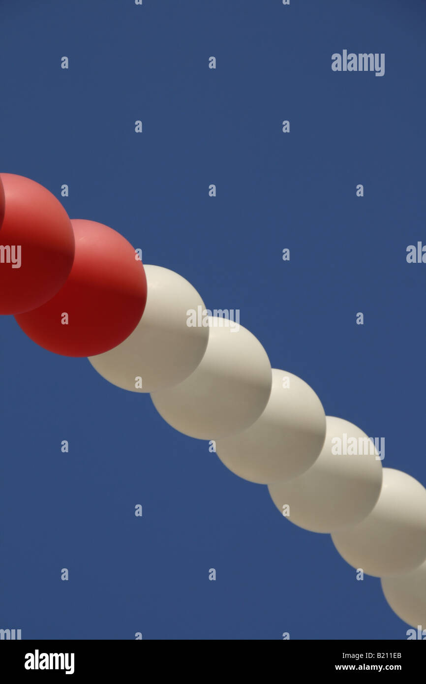 long line of red white balloons in blue sky Stock Photo - Alamy