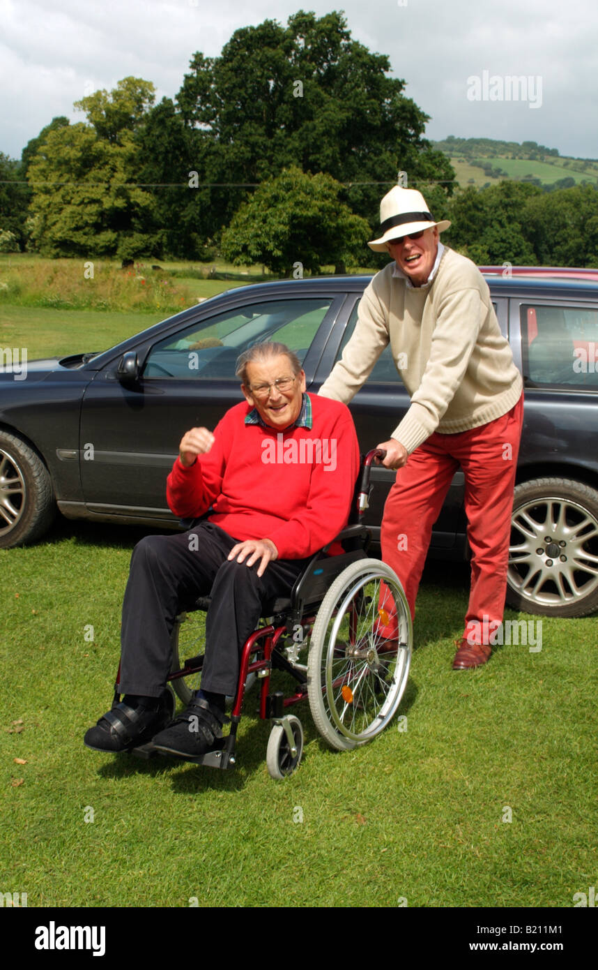 Man pushing a wheelchair and occupant Stock Photo - Alamy
