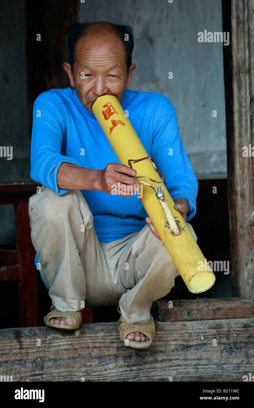 Chinese man smoking a traditional pipe at at the village of Tuanshan ...