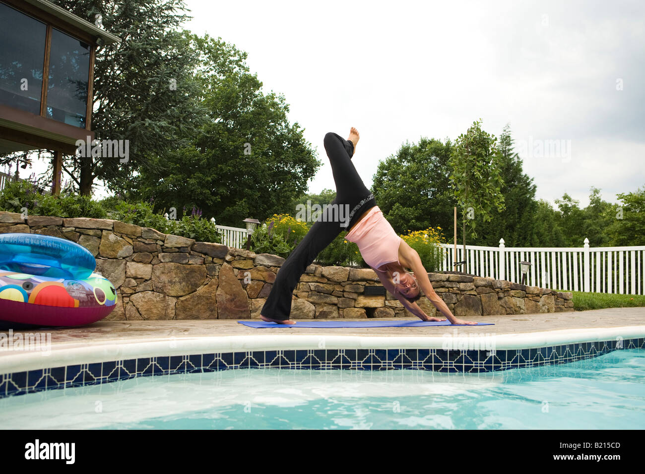 A woman doing yoga by a pool Stock Photo - Alamy