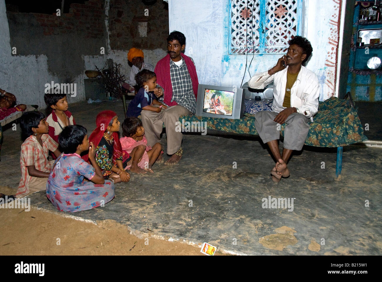 Rajasthani children watching a traditional television programme on a tv ...