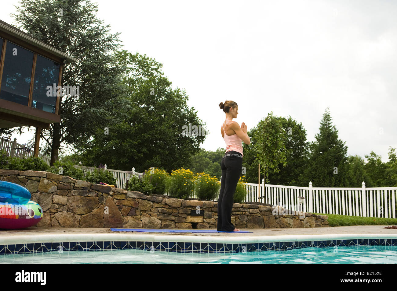 A woman doing yoga by a pool Stock Photo - Alamy