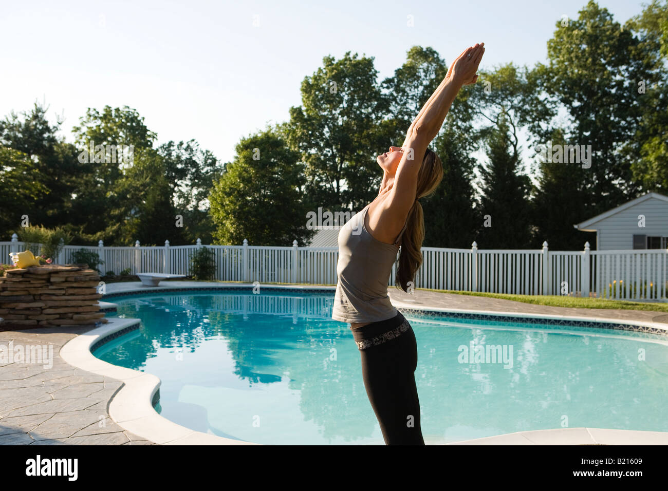 A woman doing yoga by the pool Stock Photo - Alamy