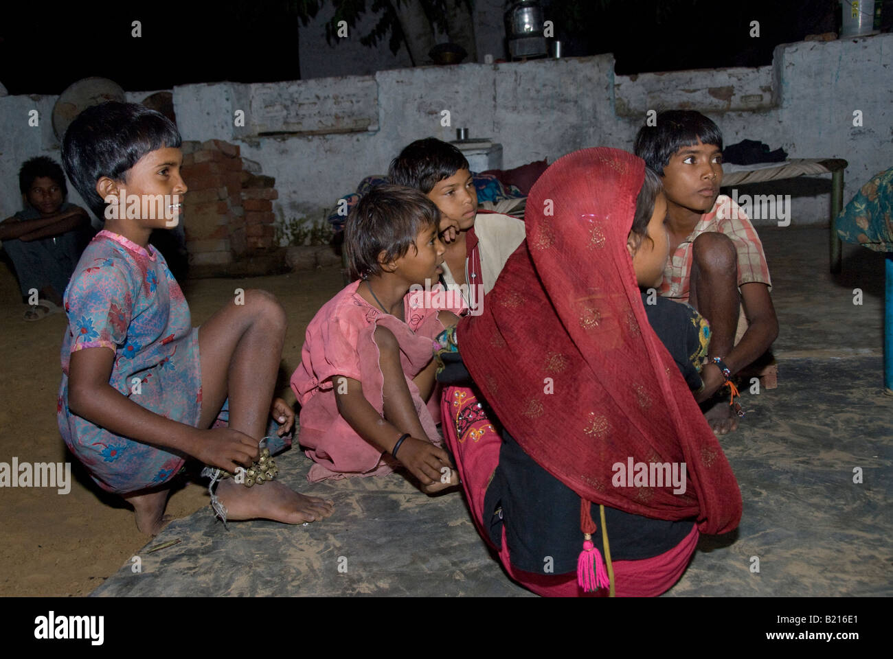 Rajasthani children watching a traditional television programme on a tv ...