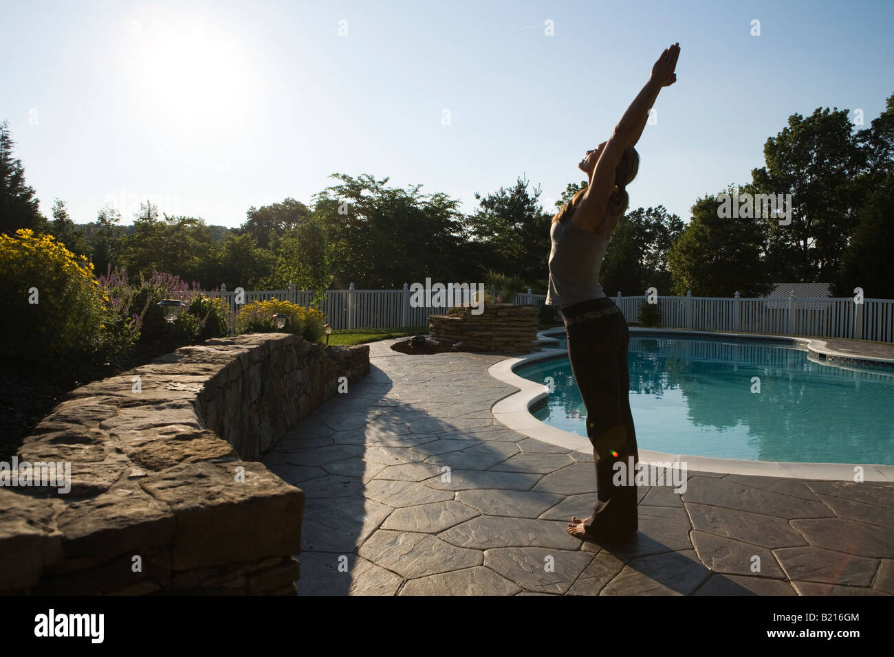 A woman doing yoga by a pool Stock Photo - Alamy