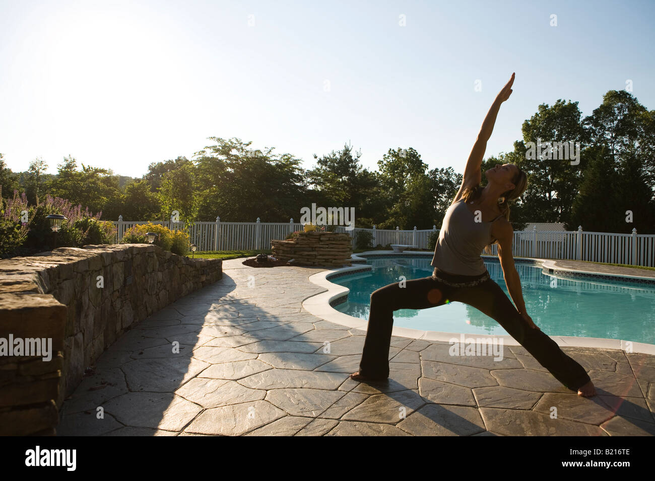 A woman doing yoga by a pool Stock Photo - Alamy