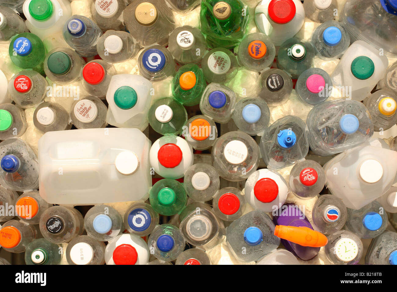 Pile stack of assorted plastic bottles with colourful lids at waste ...