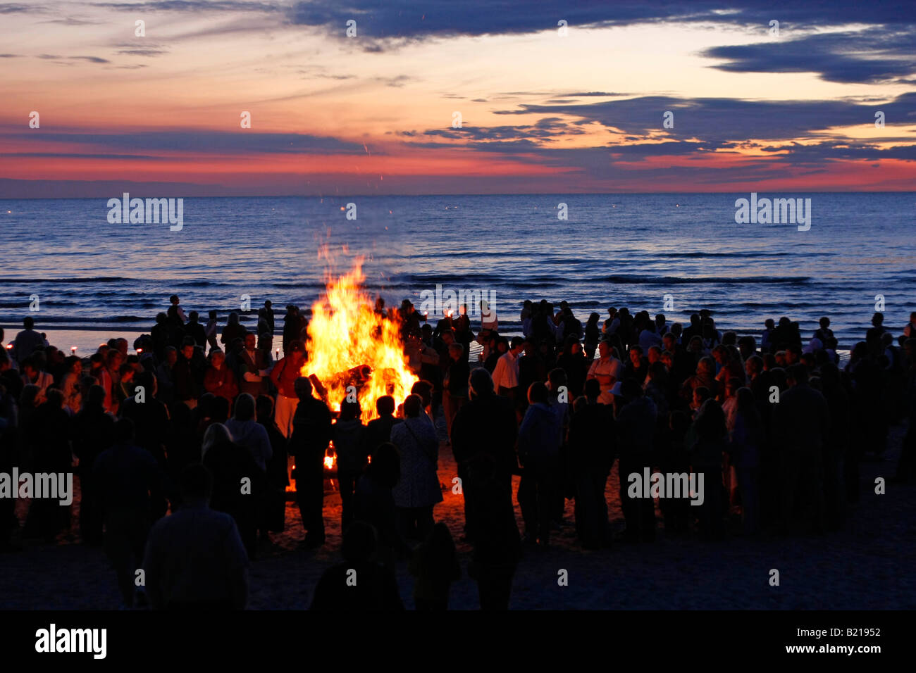 crowd gathering at a bonfire during Midsummer celebration at the beach ...