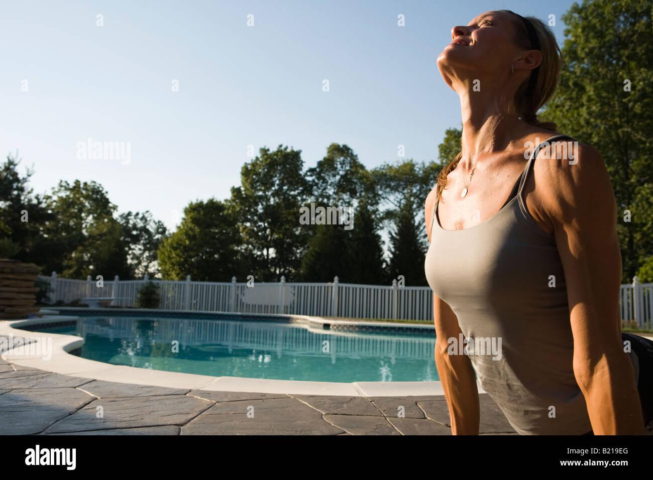 A woman stretching by a pool Stock Photo - Alamy
