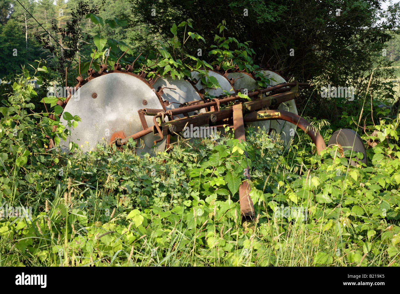 Rusted farm equipment in a New Hampshire field Stock Photo - Alamy