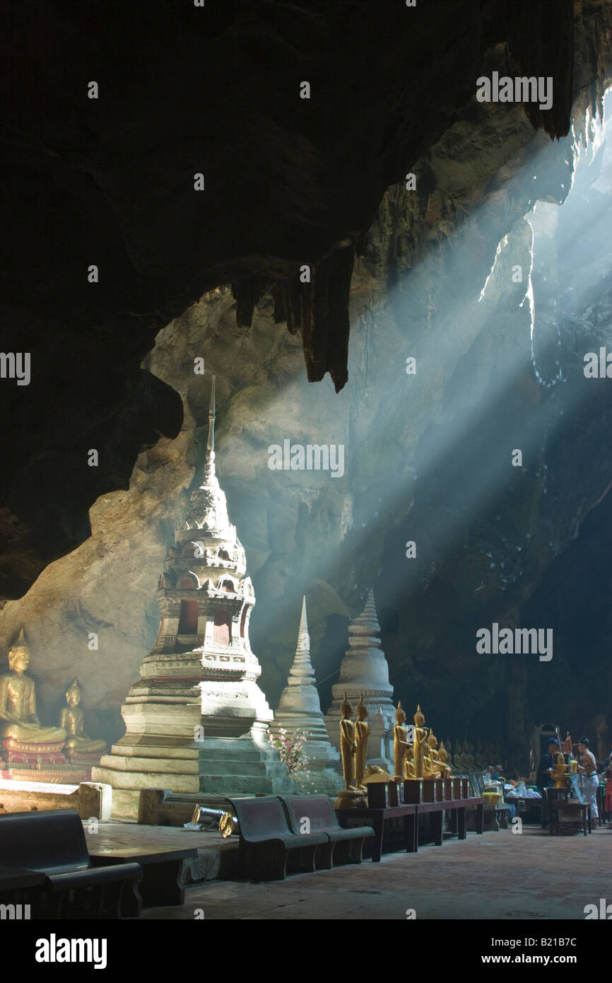 A ray of light shines on Buddha statues and pagoda inside underground ...