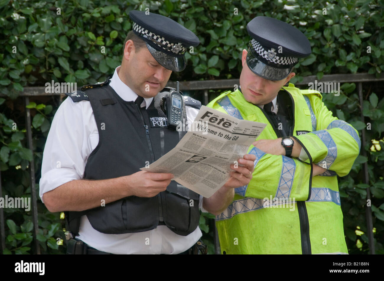 Two police officers read an anarchist news sheet about the G8 talks and ...