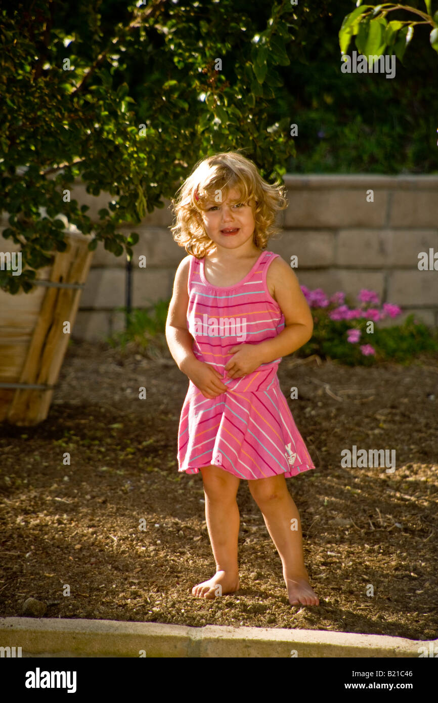 A Two Year Old Appears Angry And Confused In The Garden Of Her Home In a-two-year-old-appears-angry-and-confused-in-the-garden-of-her-home-in