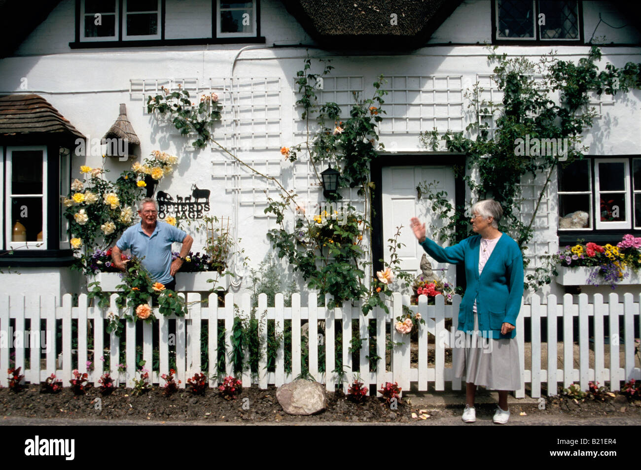 Neighbours greeting each other in front of a nicely restored cottage ...