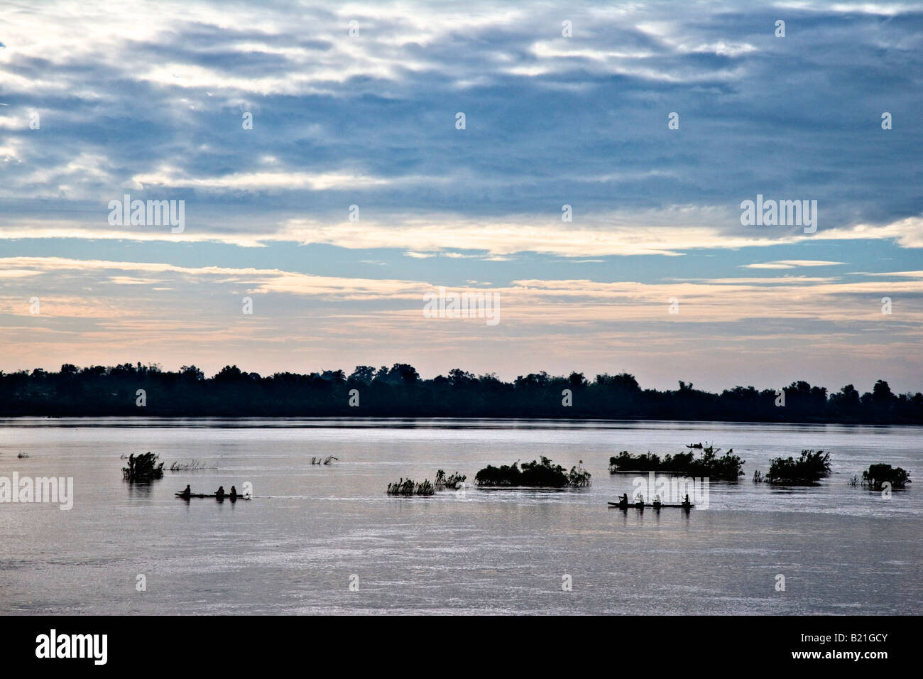 Lao folks paddle home in canoes, Don Daeng, Mekong River, southern Laos ...