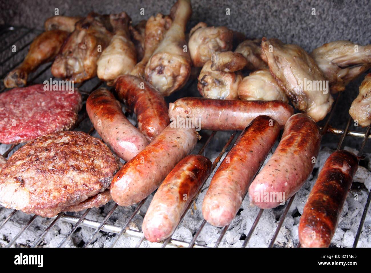 Meat cooking on an English barbeque Stock Photo - Alamy