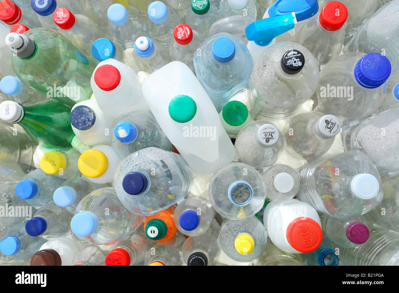 Pile stack of assorted plastic bottles with colourful lids at waste ...