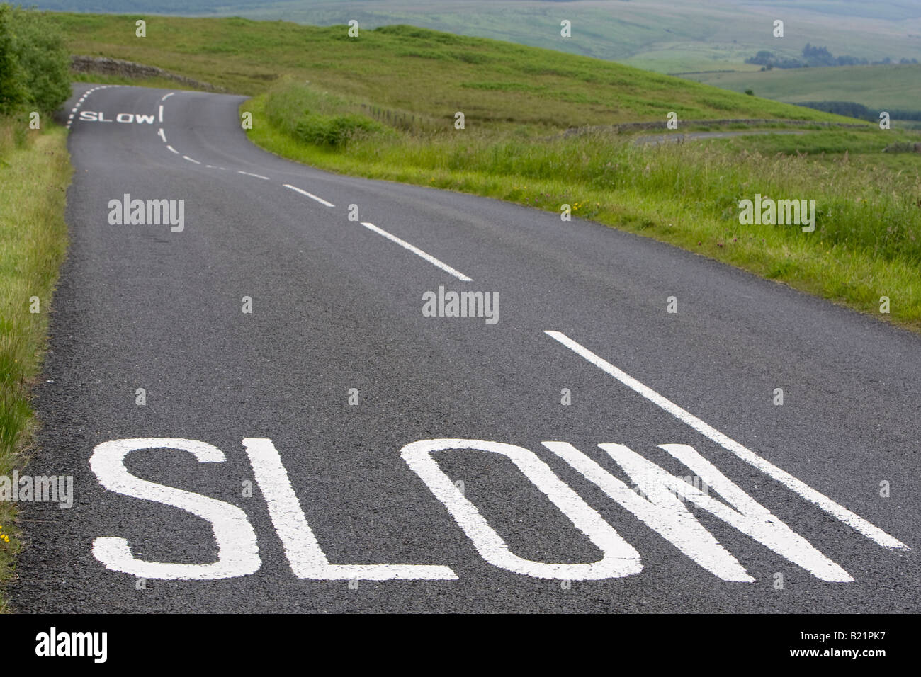 Slow sign on a country road in Northumberland UK summer Stock Photo - Alamy