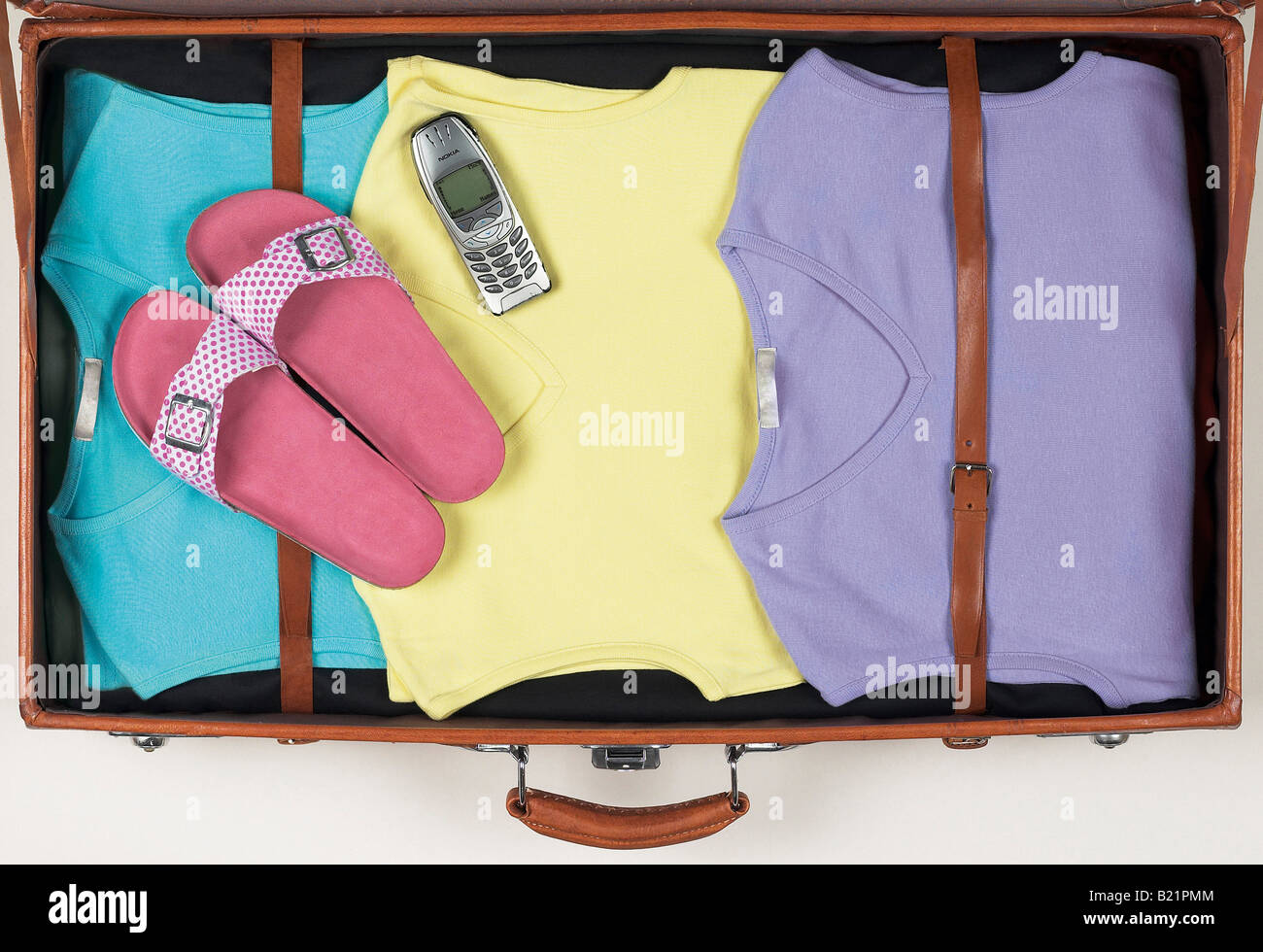 Suitcase with clothes and mobile phone inside Stock Photo - Alamy