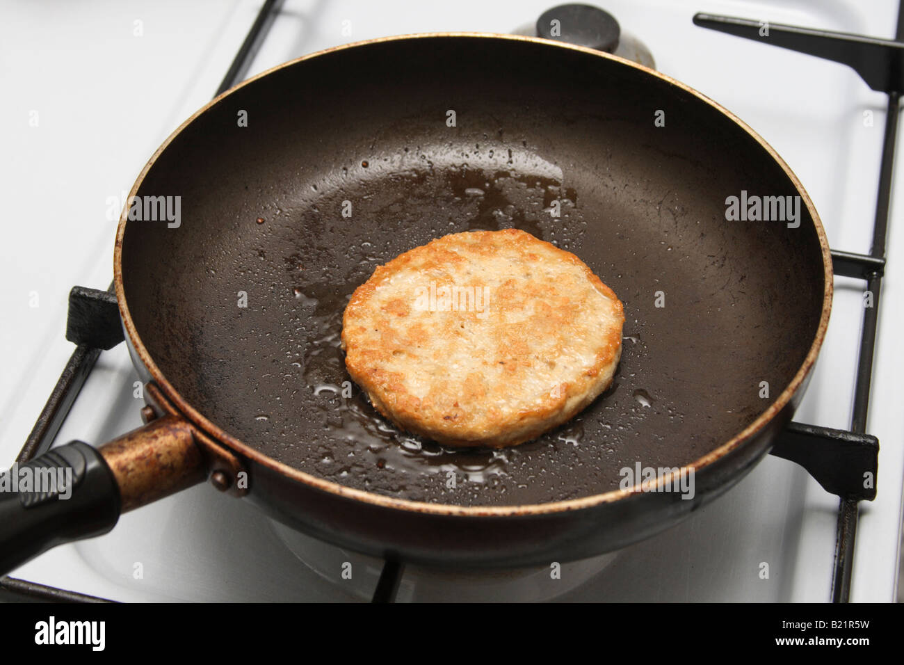 grilling a beef patty on a frying pan Stock Photo - Alamy