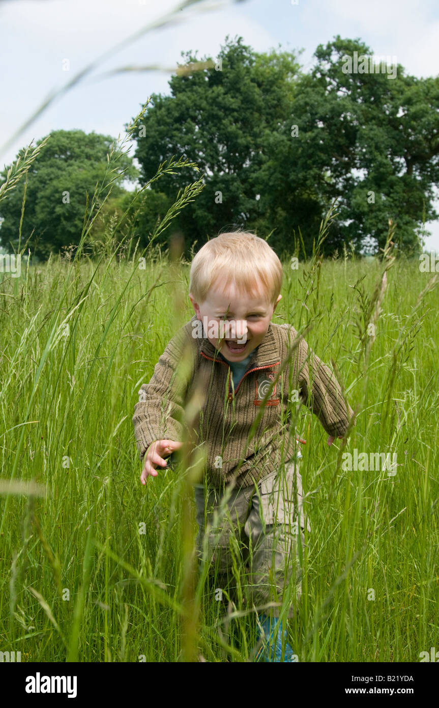 Boy running through grass Stock Photo - Alamy