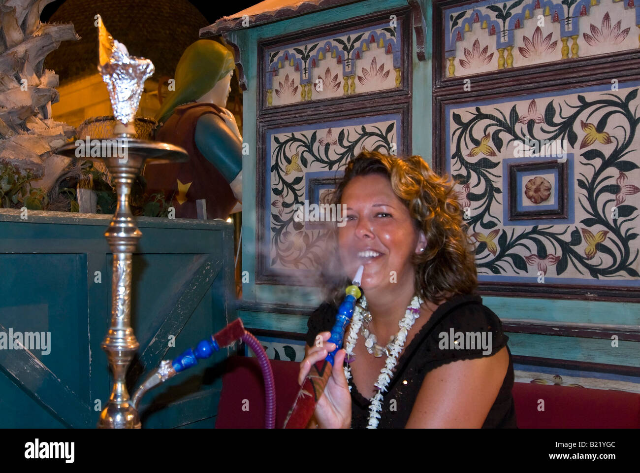 Horizontal portrait of a European female tourist smoking a shisha, aka ...