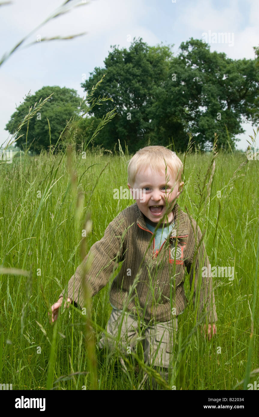 Boy running through grass Stock Photo - Alamy