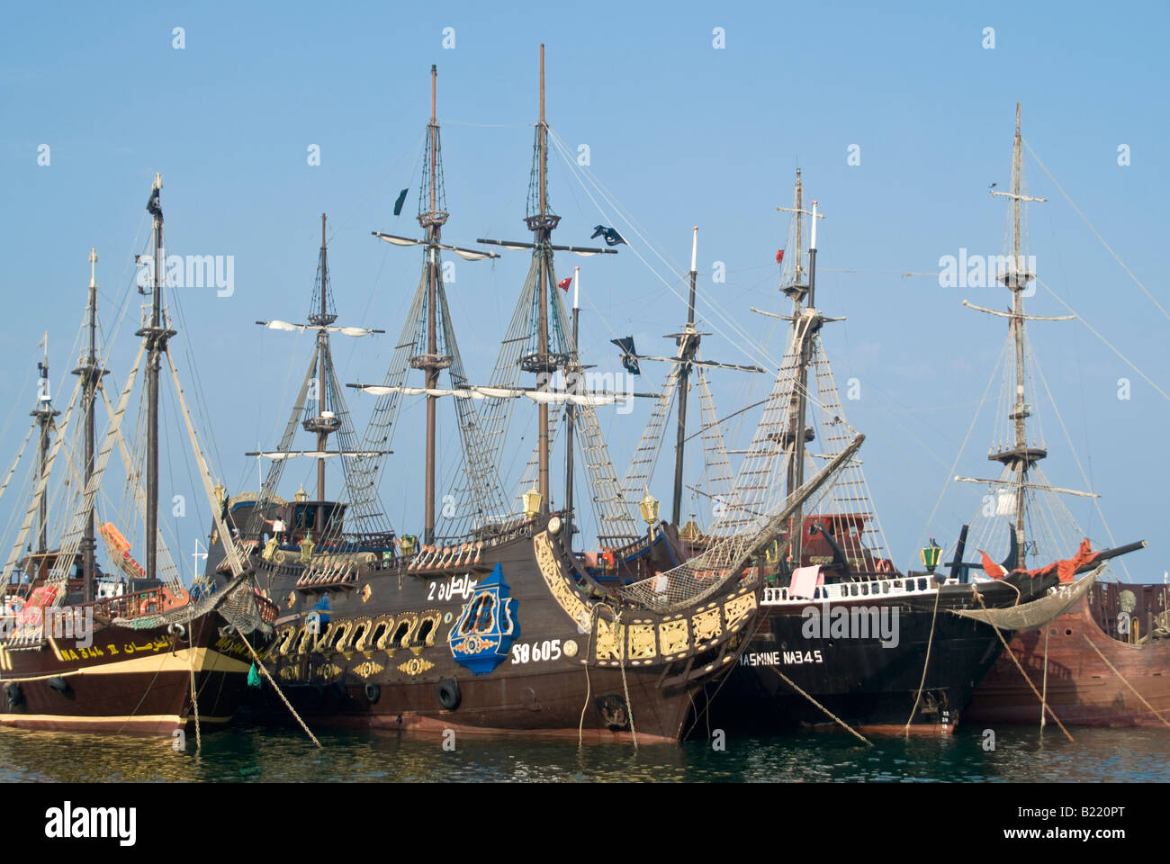 Horizontal close up of four galleon style pirate ships moored alongside ...
