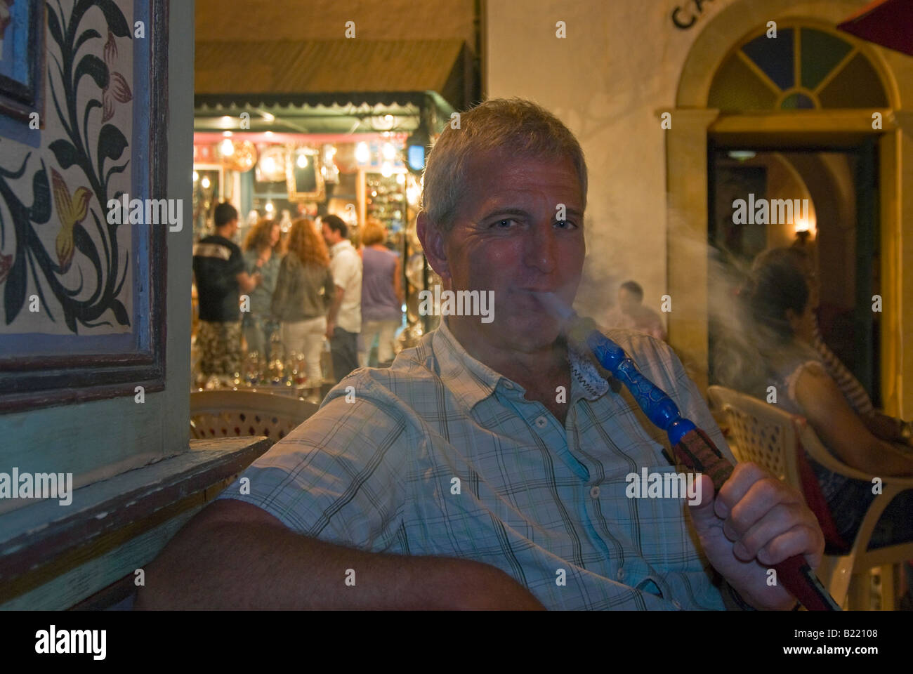 Horizontal portrait of a European male tourist smoking a shisha, aka ...
