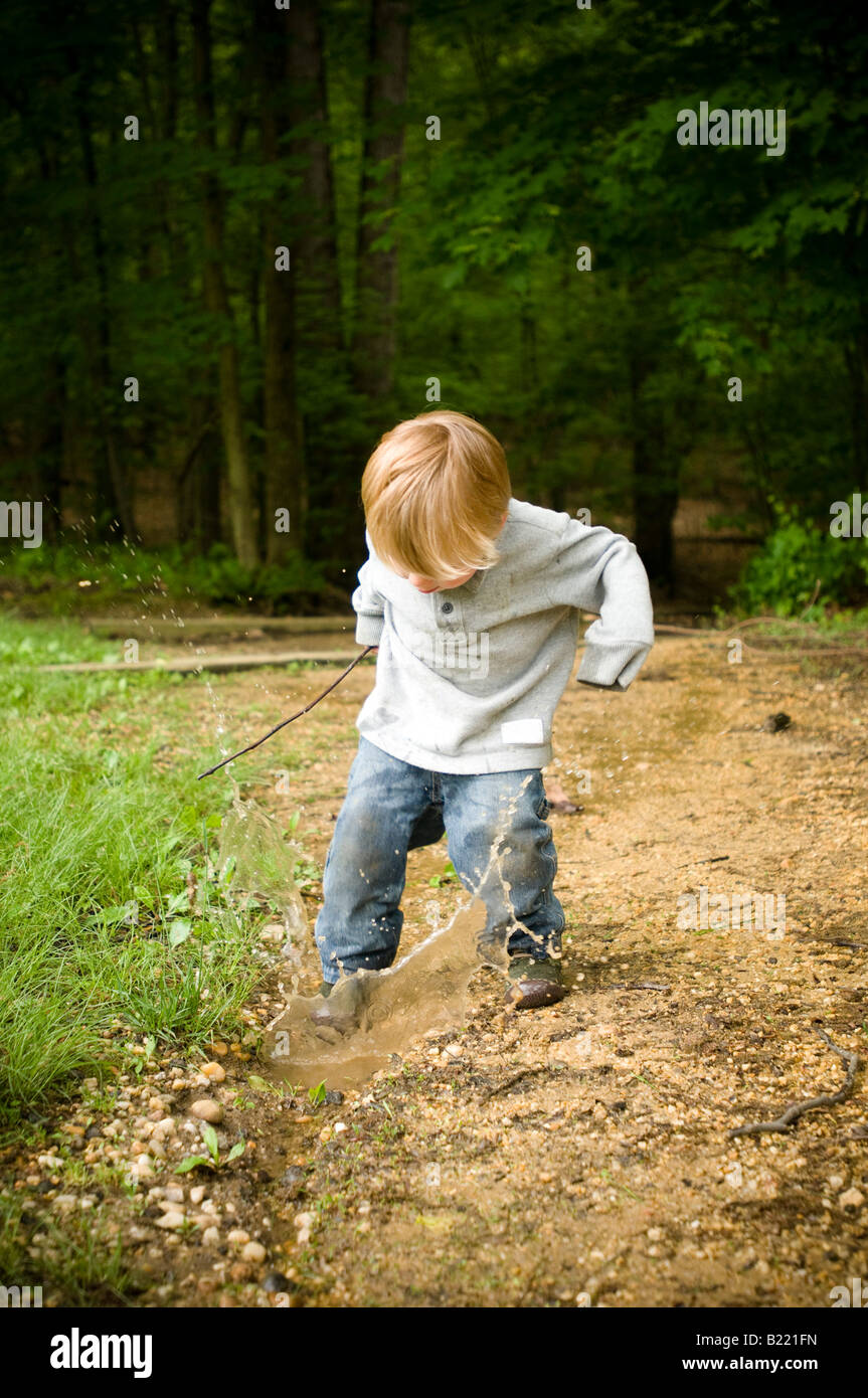Boy Splashing in Puddle Stock Photo - Alamy