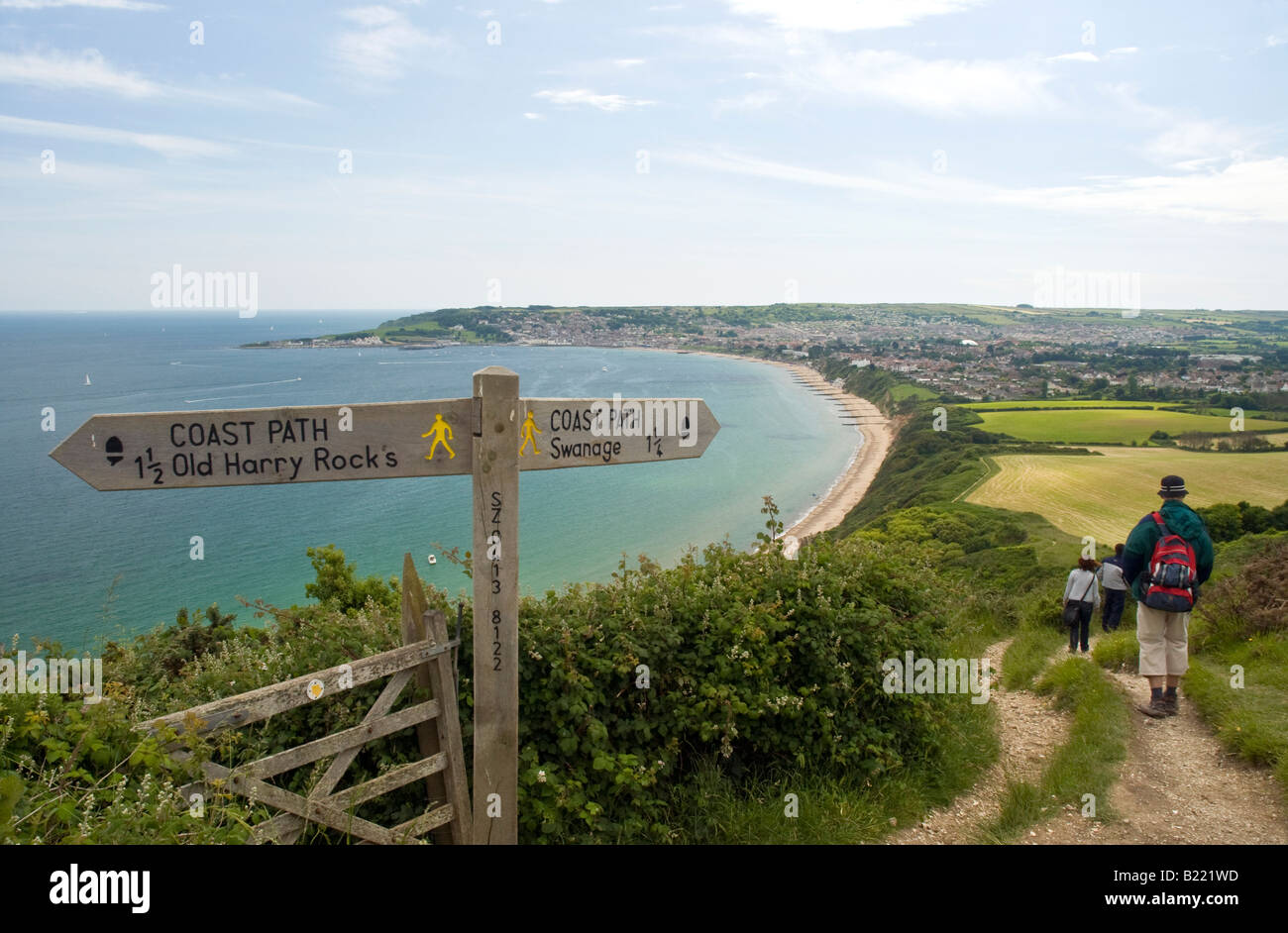 Walkers on coastal path between Old Harry Rocks and Swanage. With ...