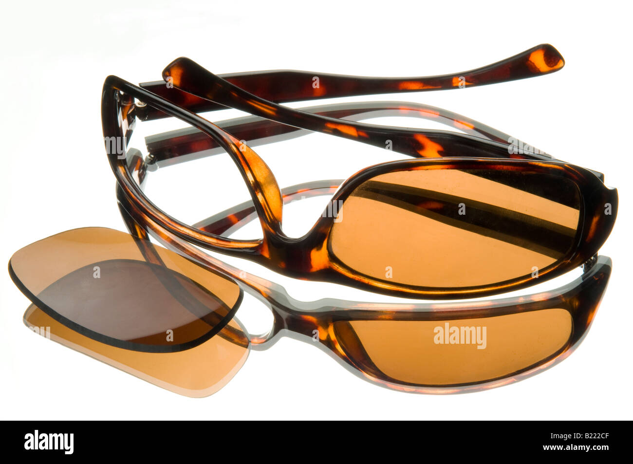 Broken sunglasses on white reflective background Stock Photo - Alamy