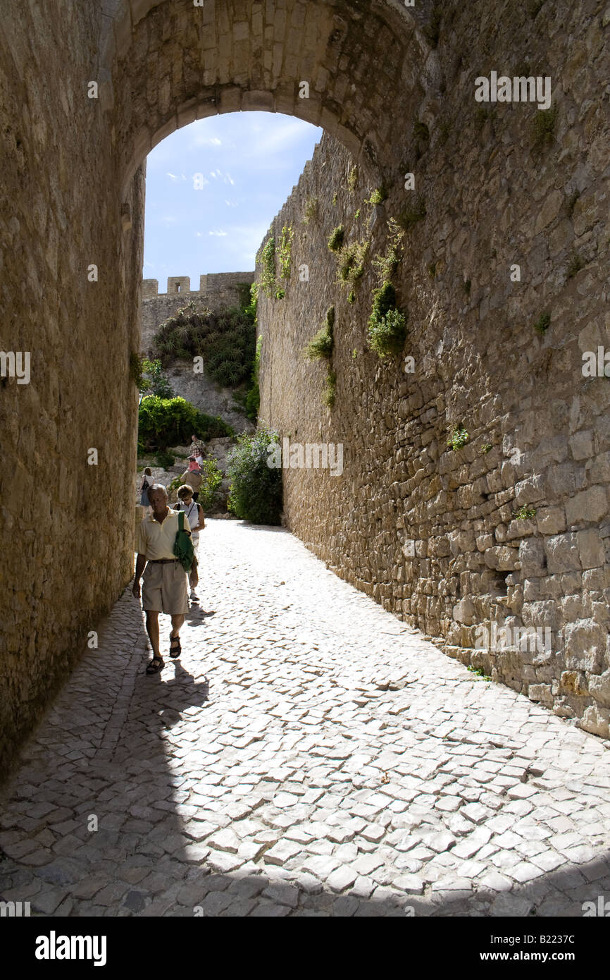 Typical street of Obidos near the castle fortifications. Obidos is a ...