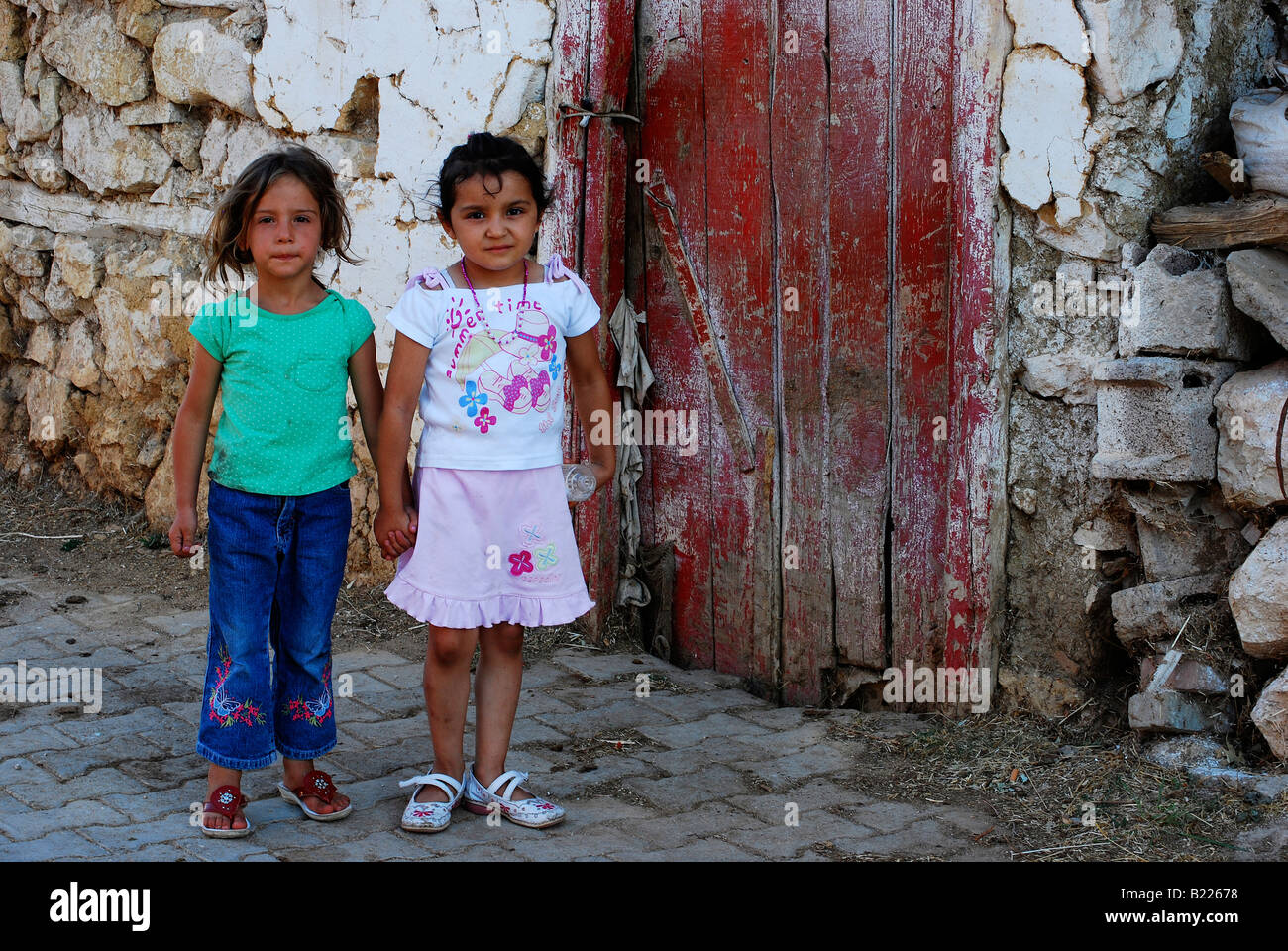 Two young girls holding hands in the village of Akpinar, on Mt Davras ...