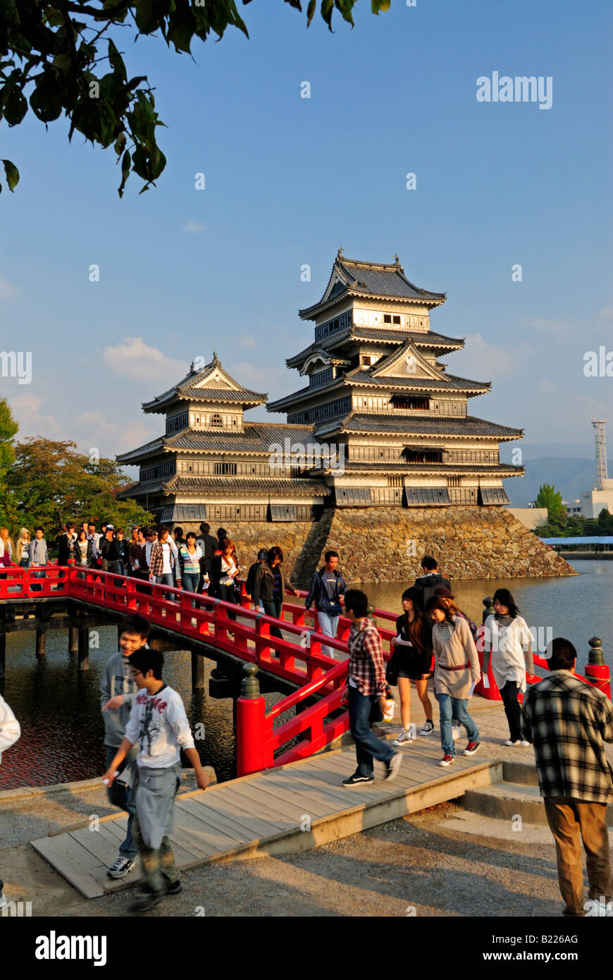 Japanese tourists walking on wooden Uzumi Bashi bridge with Matsumoto ...