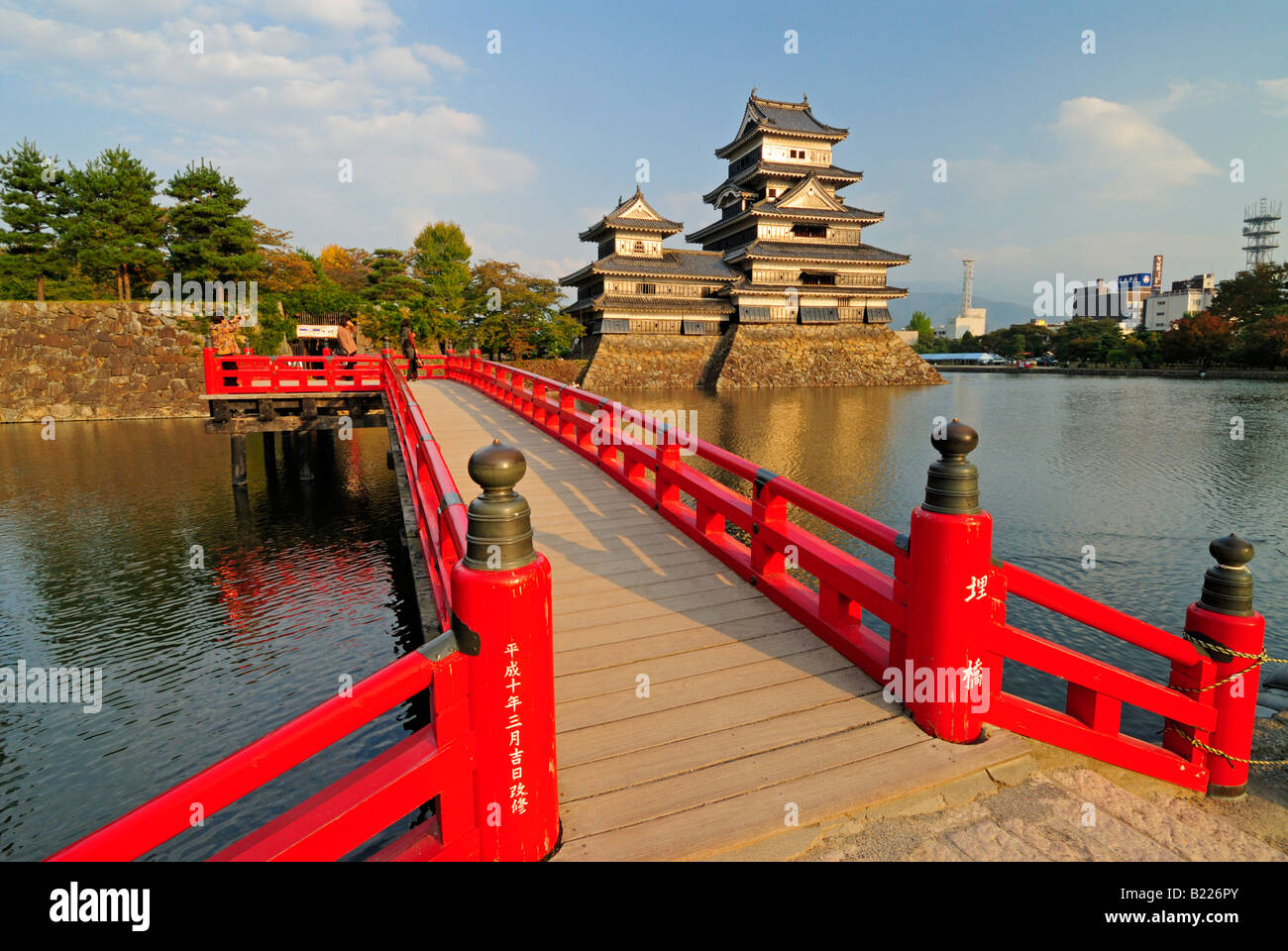 Red wooden Uzumi Bashi bridge leading to Matsumoto castle National ...