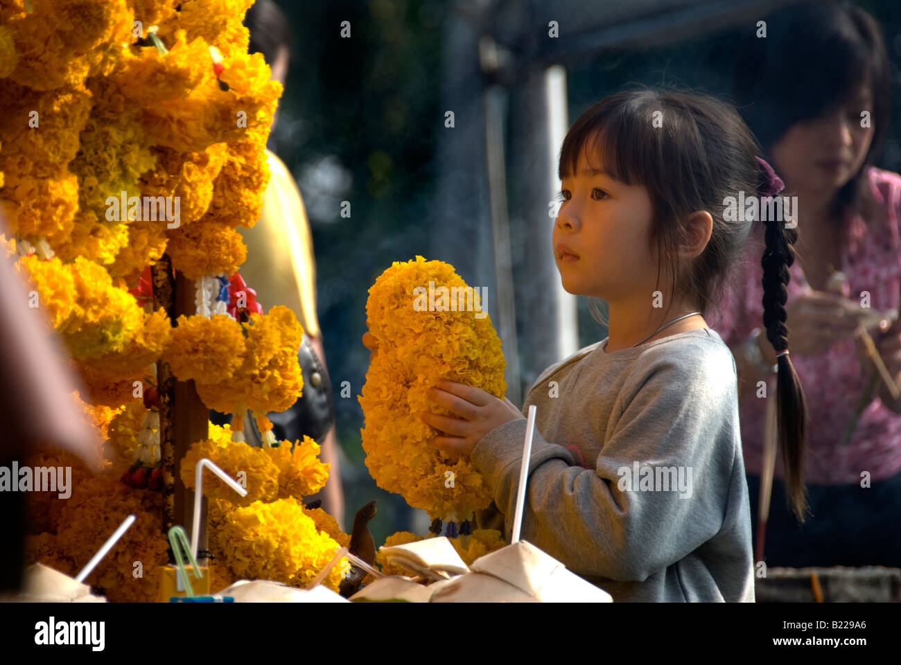 Child Making Offering at a Buddhist shrine Stock Photo - Alamy