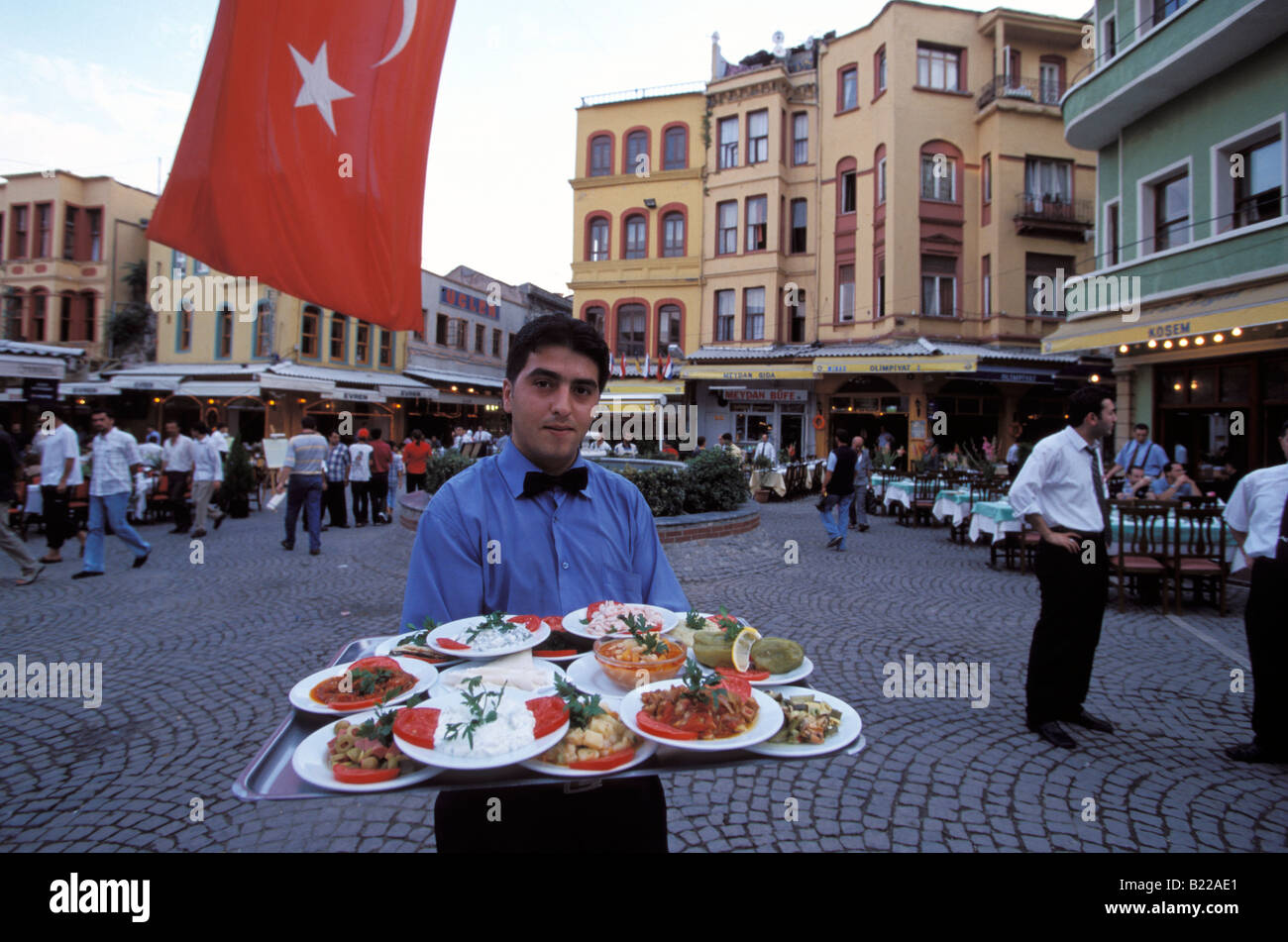 Waiter of the fish restaurant Kumkapi serving Turkish starters Istanbul ...