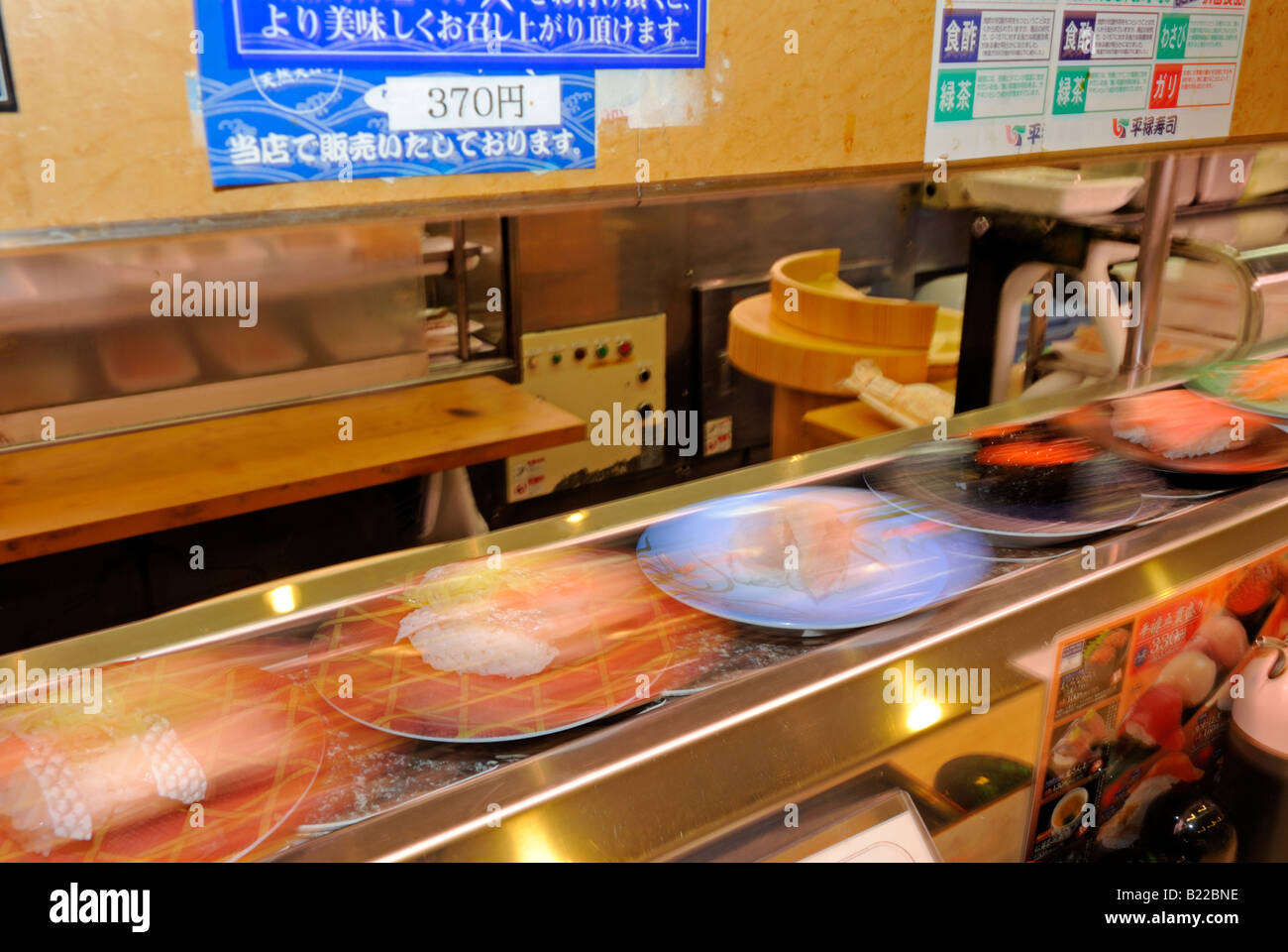 Plates with sushi circling around on conveyor belt in Japanese sushi ...