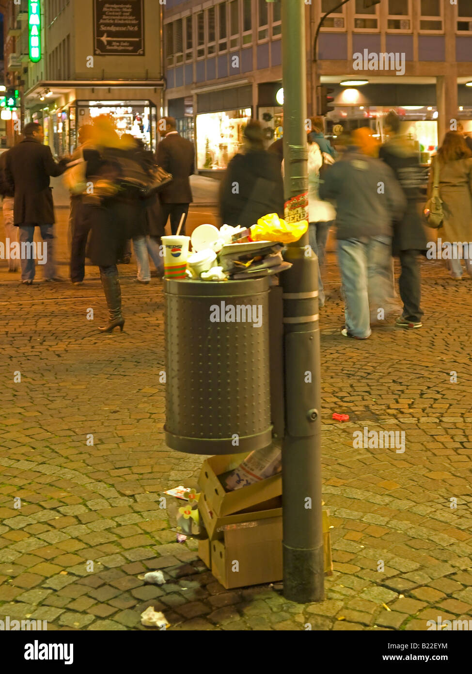 trash rubbish garbage and a full waste bin garbage can in pedestrian ...