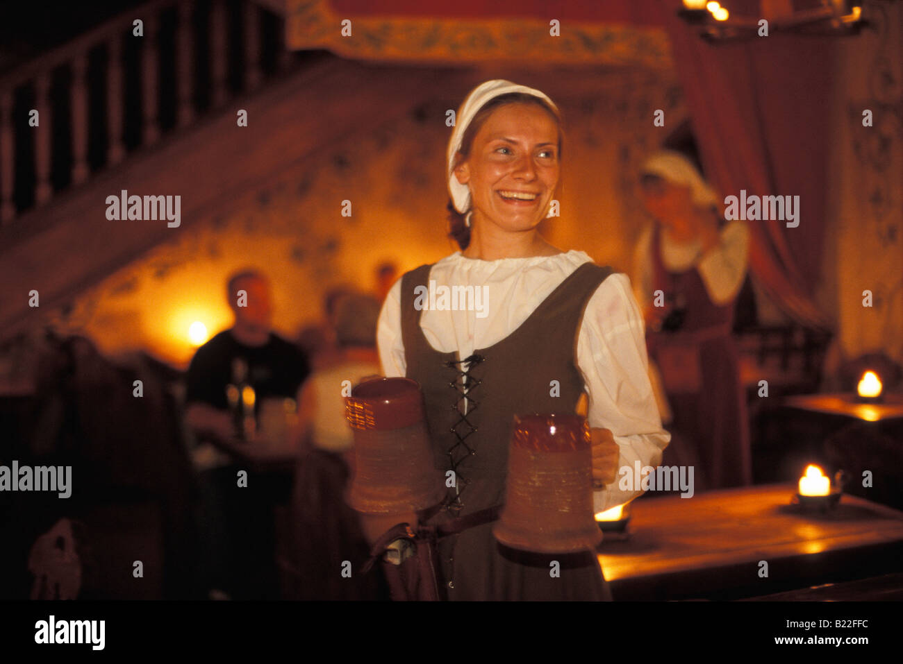 Waitress in traditional dress serving honey beer in a medieval theme ...