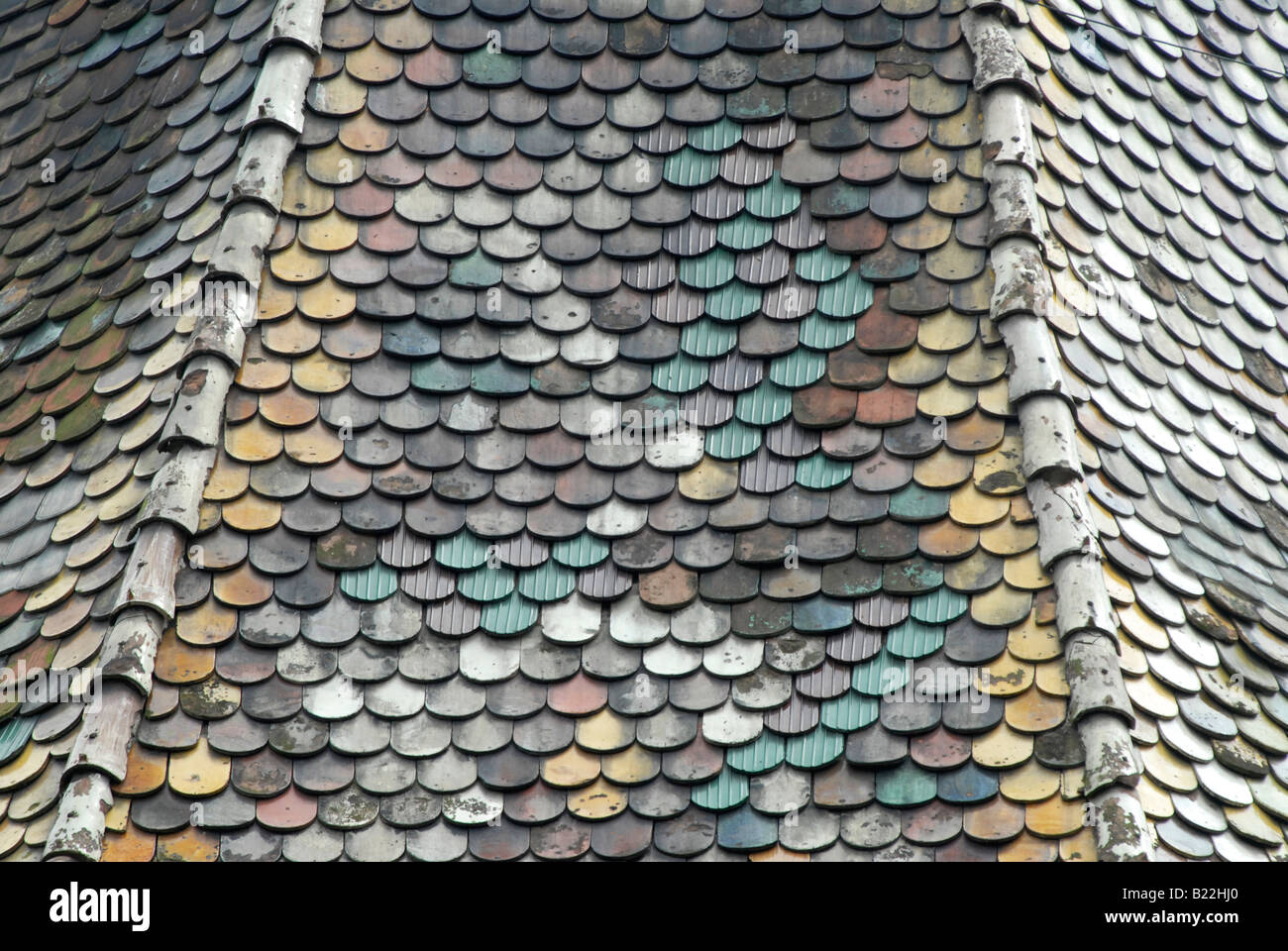 Steep roofs with coloured tiles on a clock tower in a romanian city ...