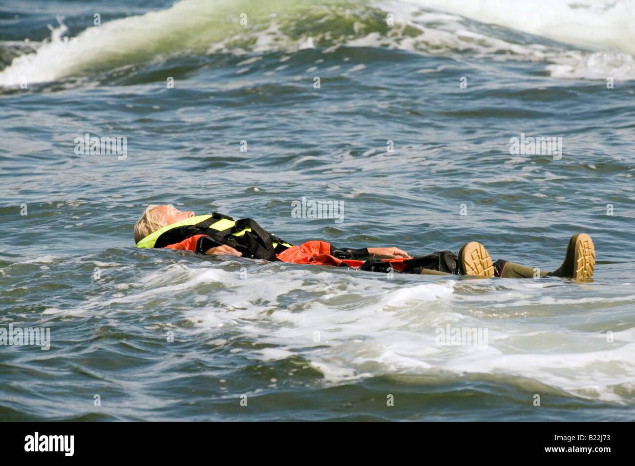 A person in dry survival suit floats on water surface Stock Photo - Alamy