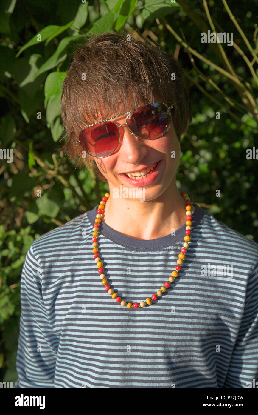 Hippy boy portrait smiling wearing shades and necklace Stock Photo - Alamy