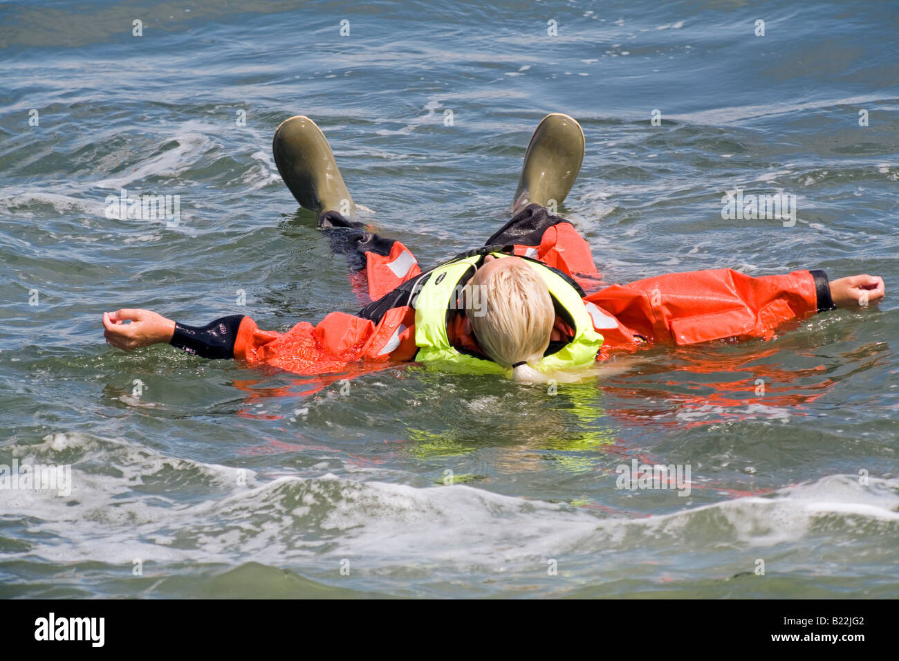 A person in dry survival suit floats on water surface Stock Photo - Alamy