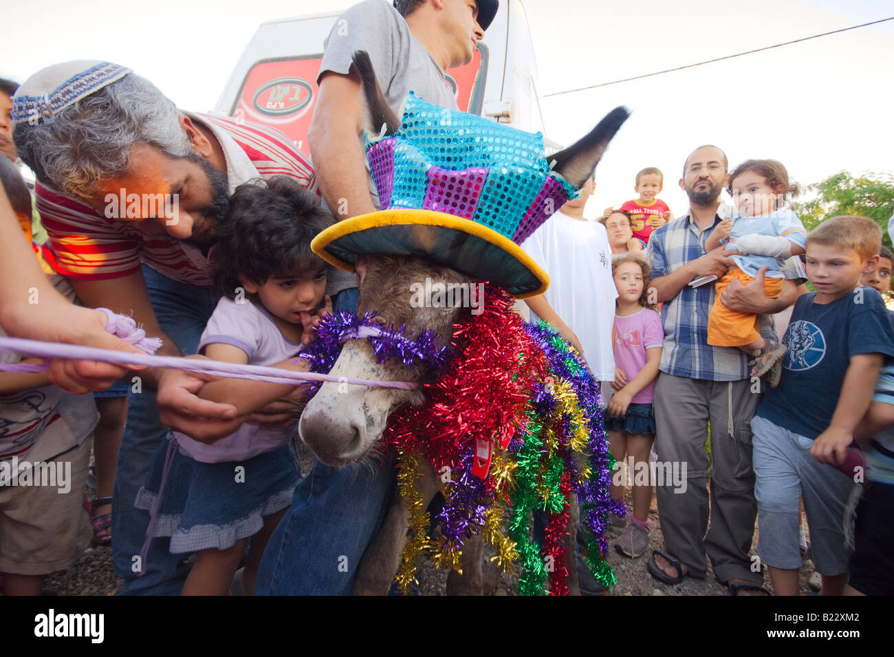 A father and his daughter look at an ornamented donkey during a Jewish ...