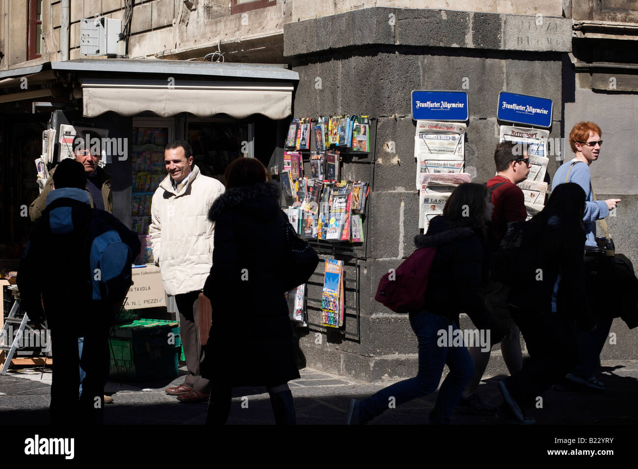 Pedestrian walk past a newsstand selling magazines and newspapers in ...