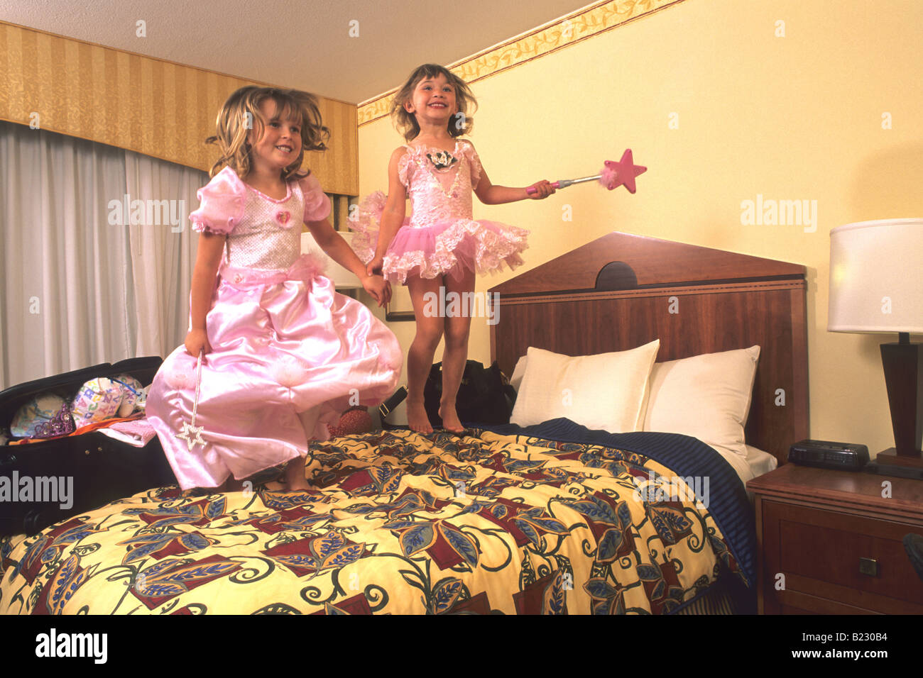 two girls jumping on bed Stock Photo - Alamy