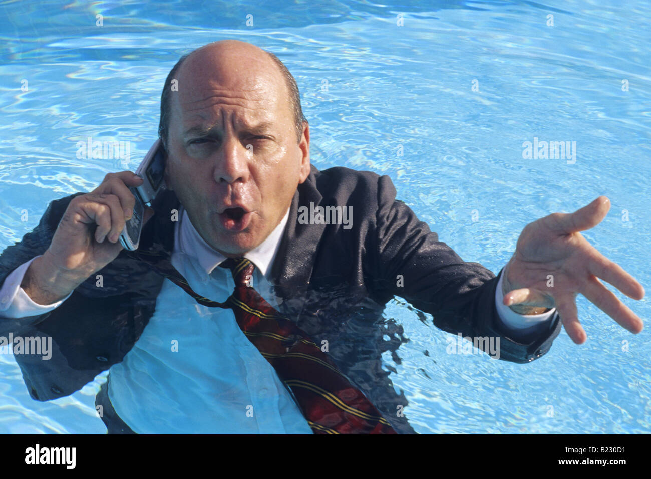 Businessman using mobile phone in swimming pool Stock Photo - Alamy